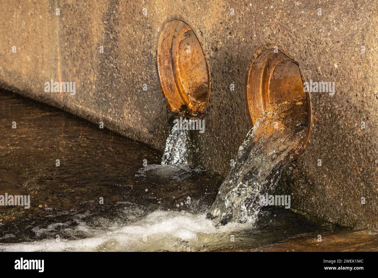 Water flowing through pipes beneath causeway Stock Photo - Alamy
