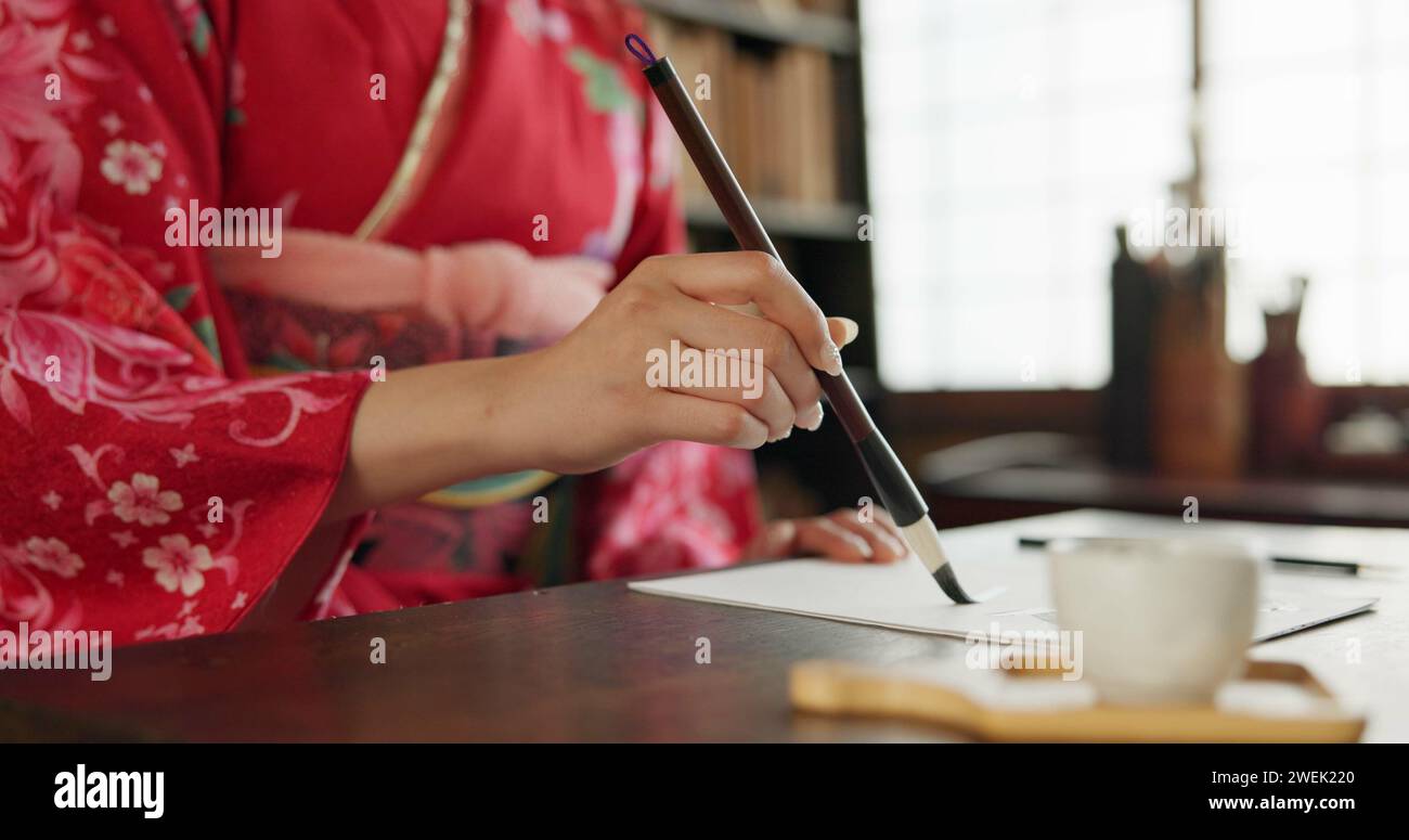 Ink, calligraphy and hands of Japanese woman in home for traditional ...