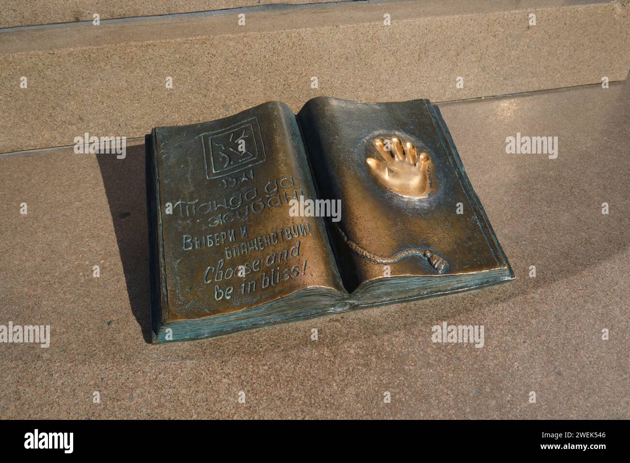 Sculpture of an open book with handprint and quote. At the base of the ...