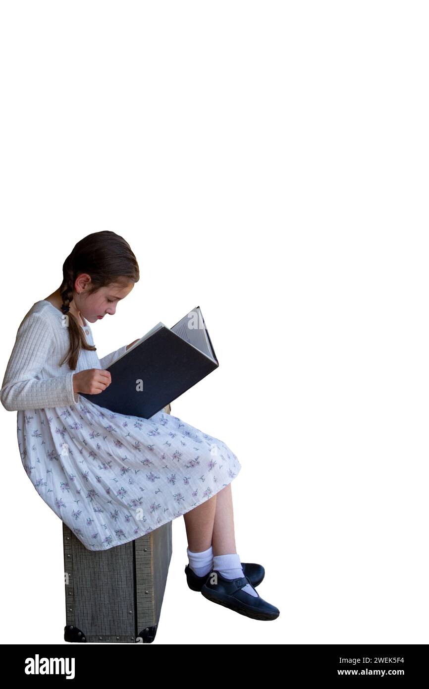 Little girl reading a book while she's waiting, cut out on white ...