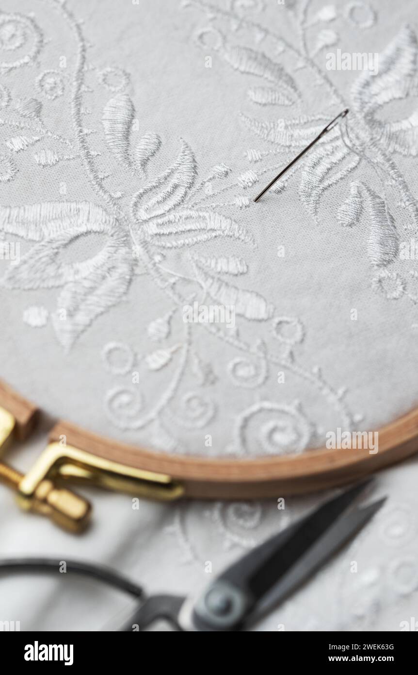 The process of hand embroidering a shirt with white threads on white ...