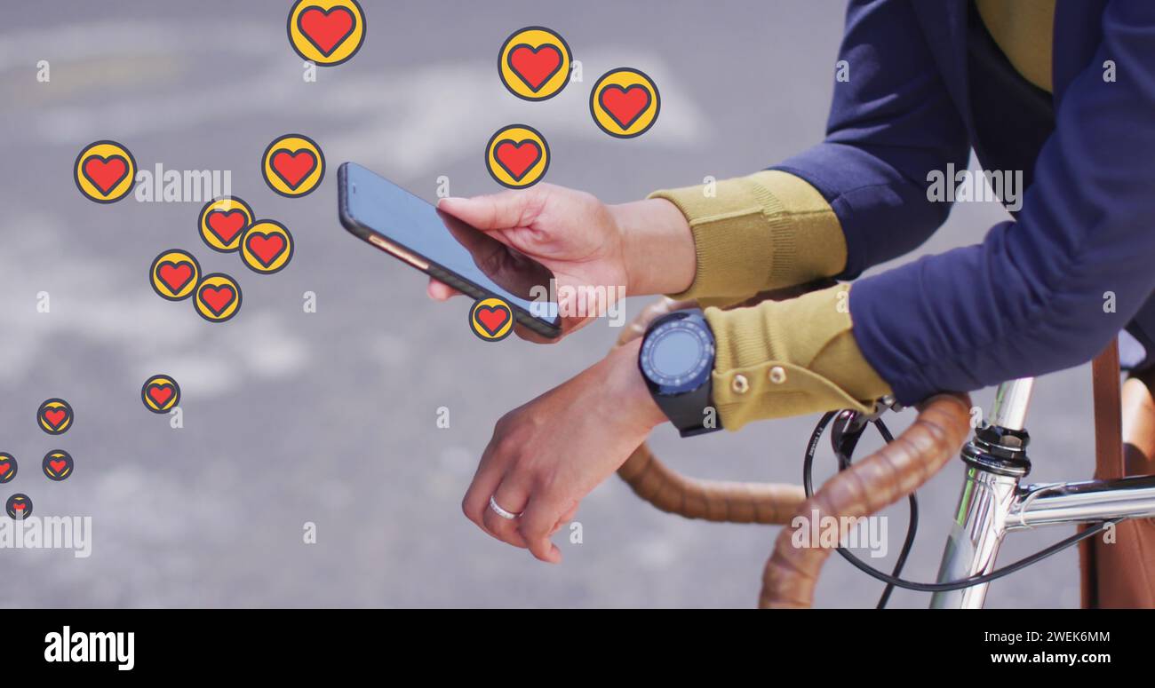 Multiple heart icons floating against mid section of woman with bicycle ... Multiple heart icons floating against mid section of woman with bicycle ...