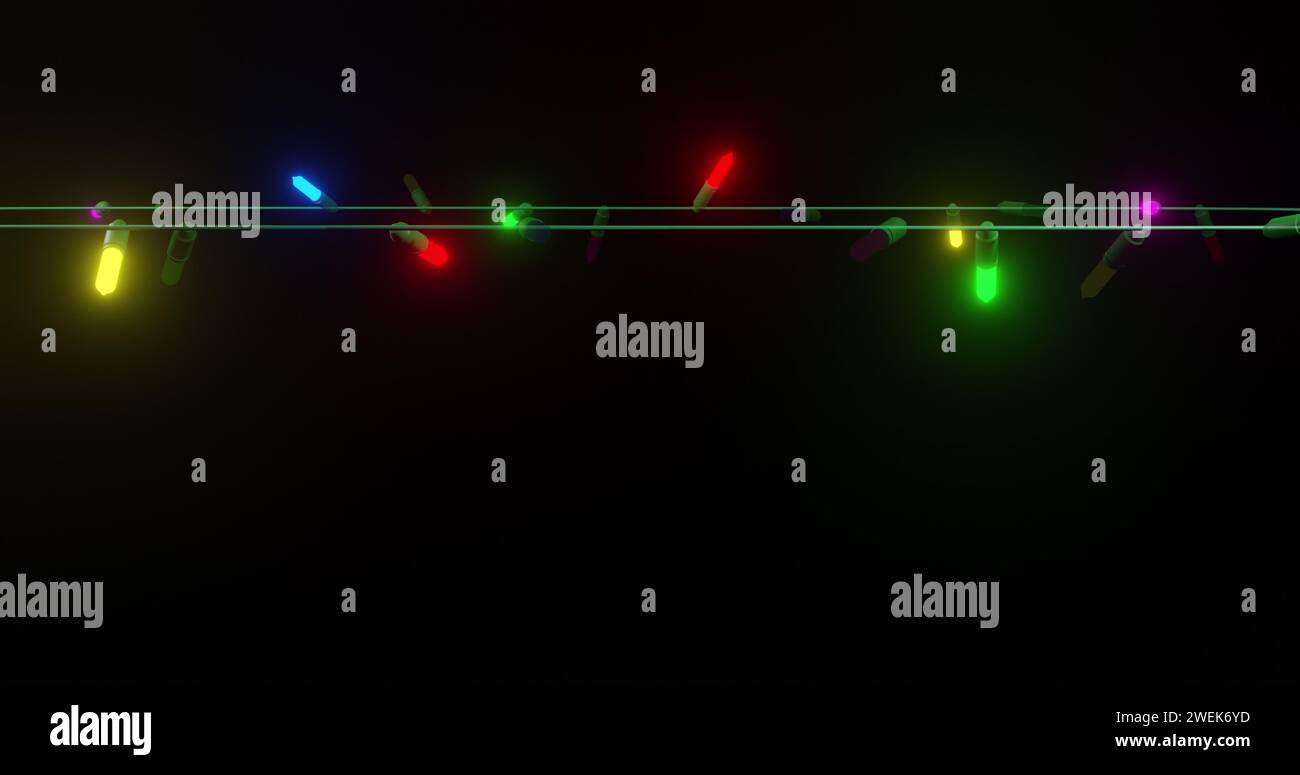 Strand of coloured christmas string lights flashing on black background ...