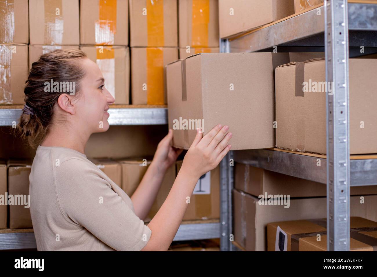 A woman packs boxes, puts the box on the rack. Delivery of goods ...
