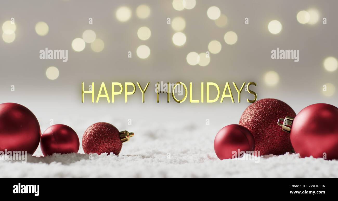 Happy holidays text with glittery red christmas baubles on snow and ...