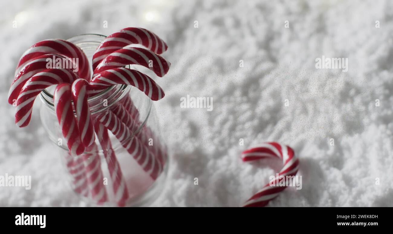 Candy canes spill from a jar onto a snowy surface Stock Photo - Alamy
