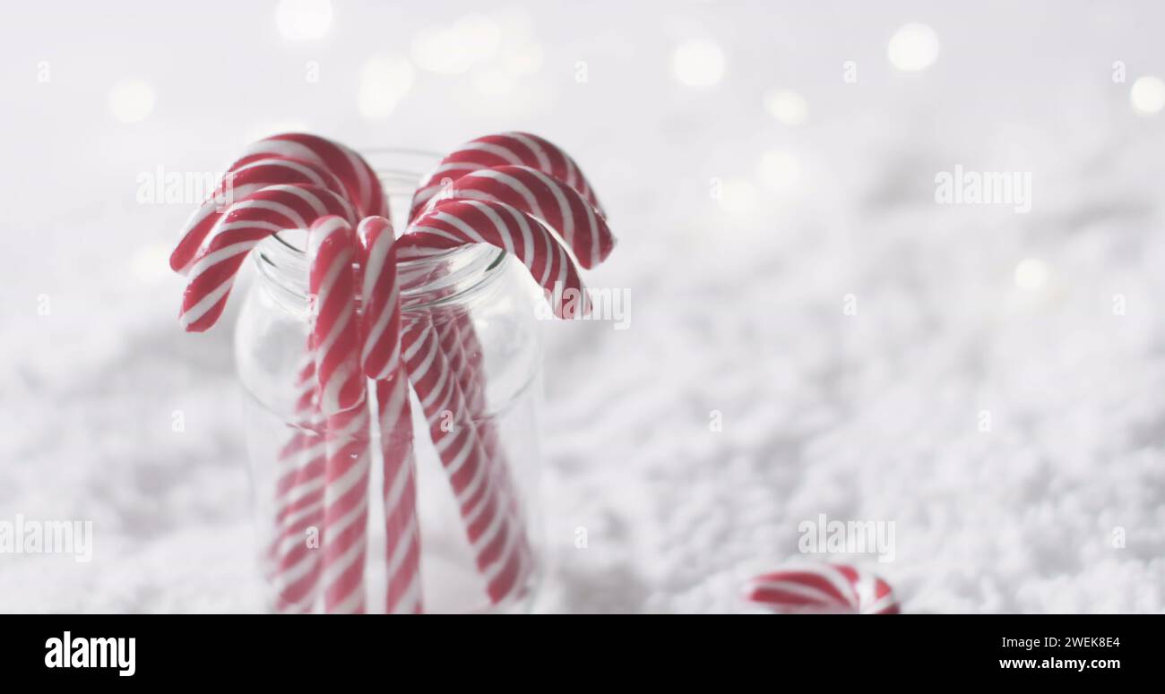 Candy canes in a jar set against a snowy backdrop, with copy space ...