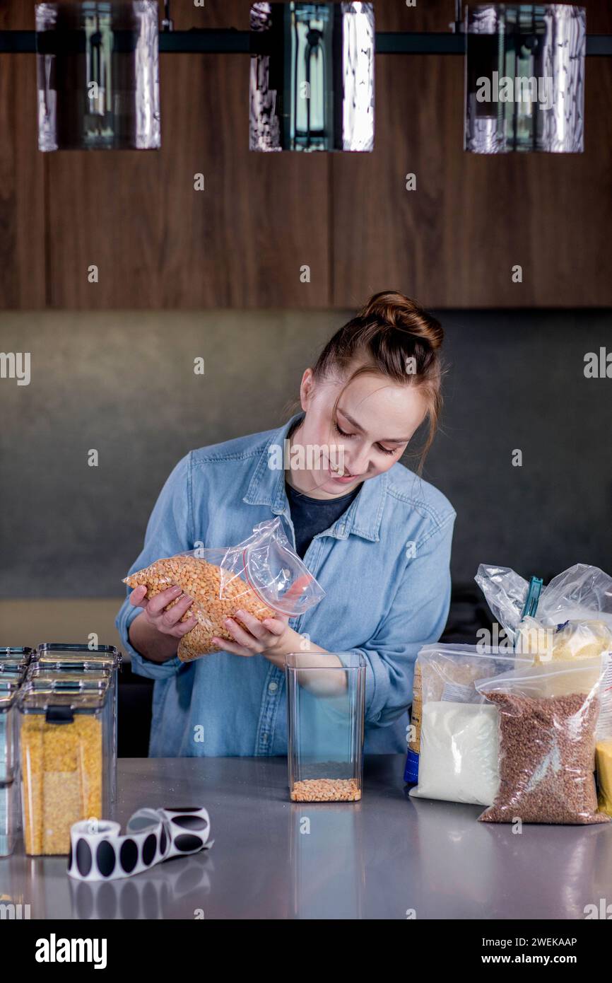 A woman uses containers to organize food in the kitchen. Layout and ...