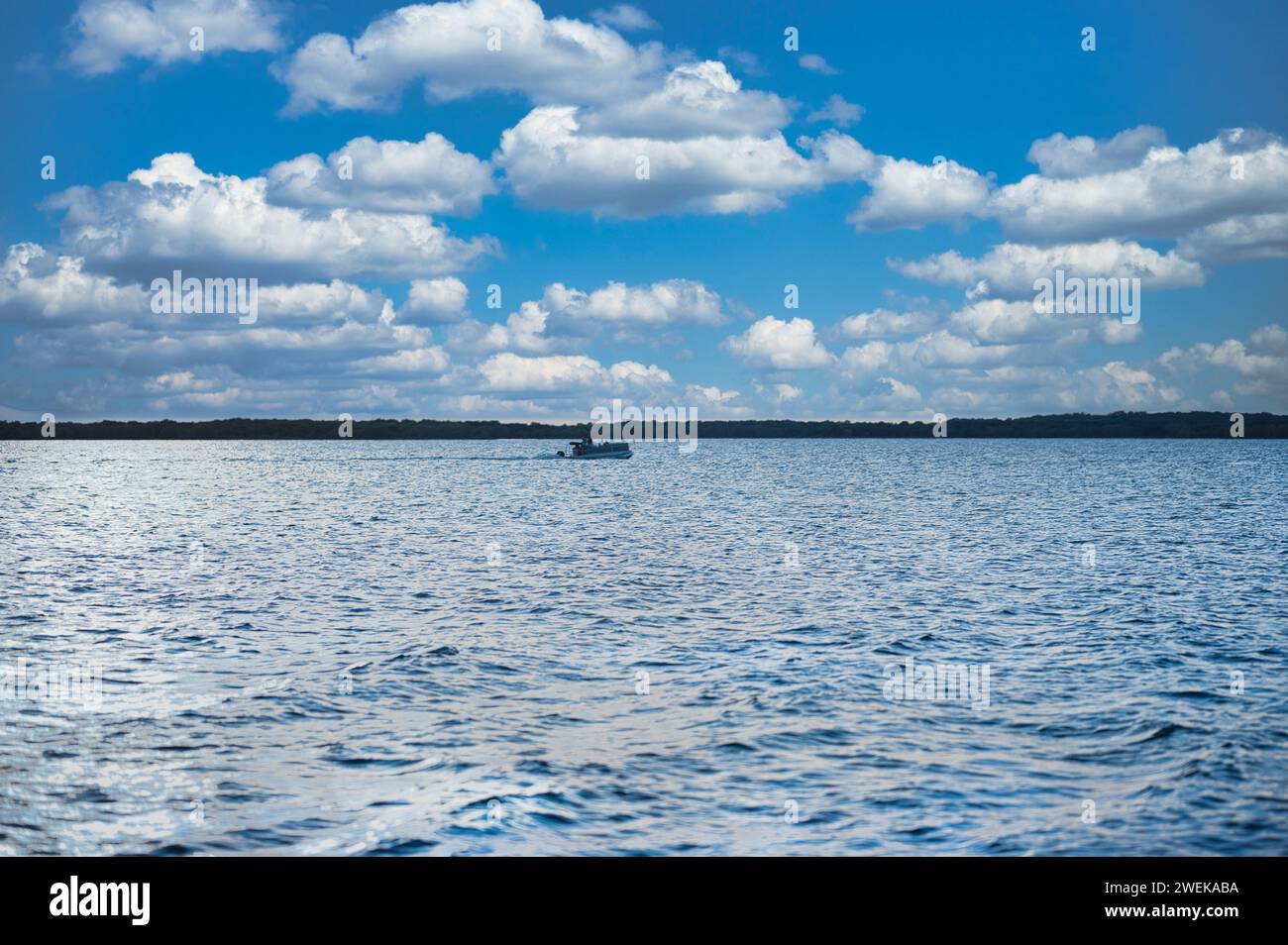 Boats sailing in the vast open ocean with dramatic cloudy skies on a ...