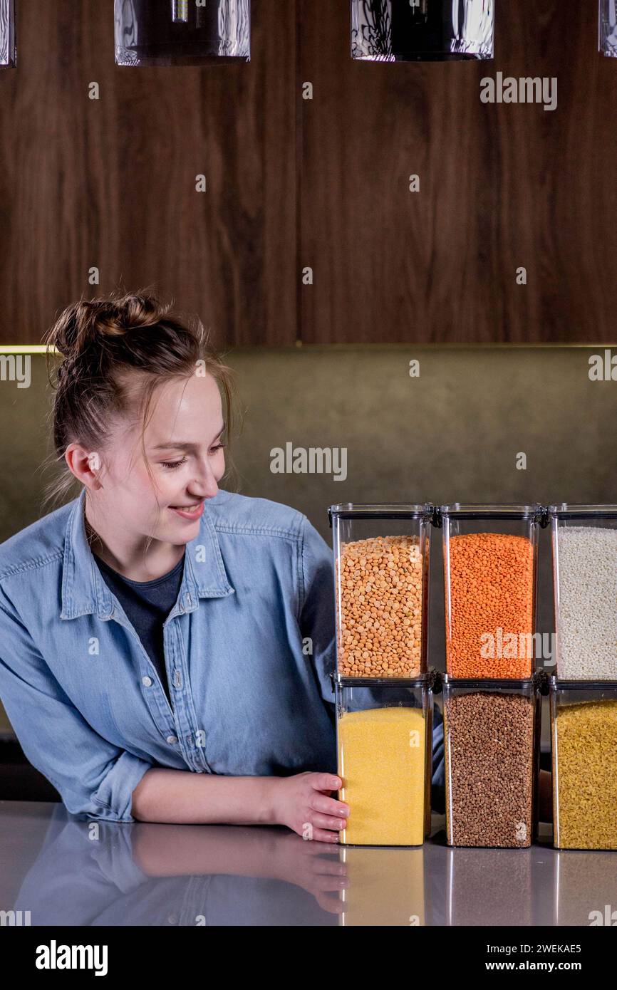 A woman uses containers to organize food in the kitchen. Layout and ...