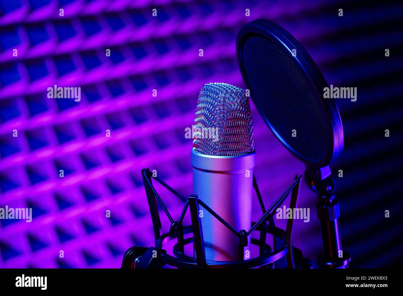 Professional studio microphone against acoustic foam panel background ...