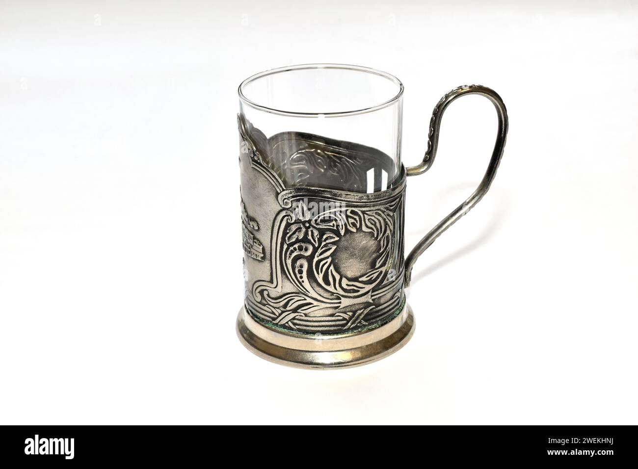 A glass glass sits in a metal cup holder. Tea is served in such glasses ...