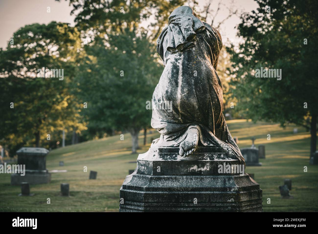 A captivating statue of a mourning woman stands gracefully amidst the ...