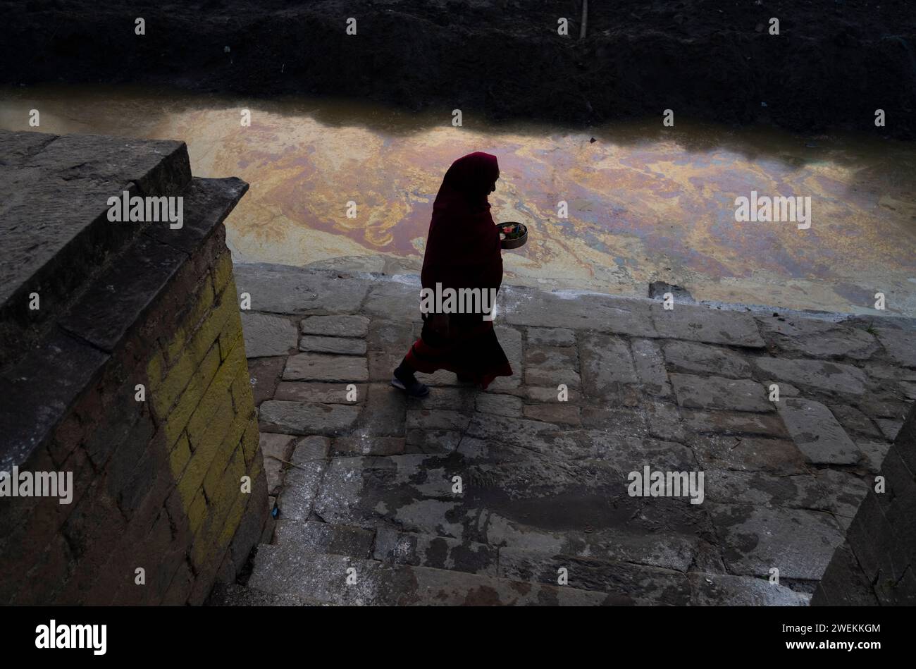 A Hindu devotee arrives to perform rituals by a polluted Hanumante ...