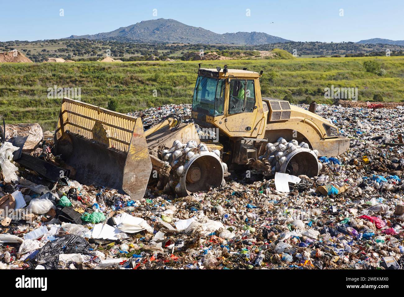 Heavy machinery shredding garbage in an open air landfill. Waste Stock ...