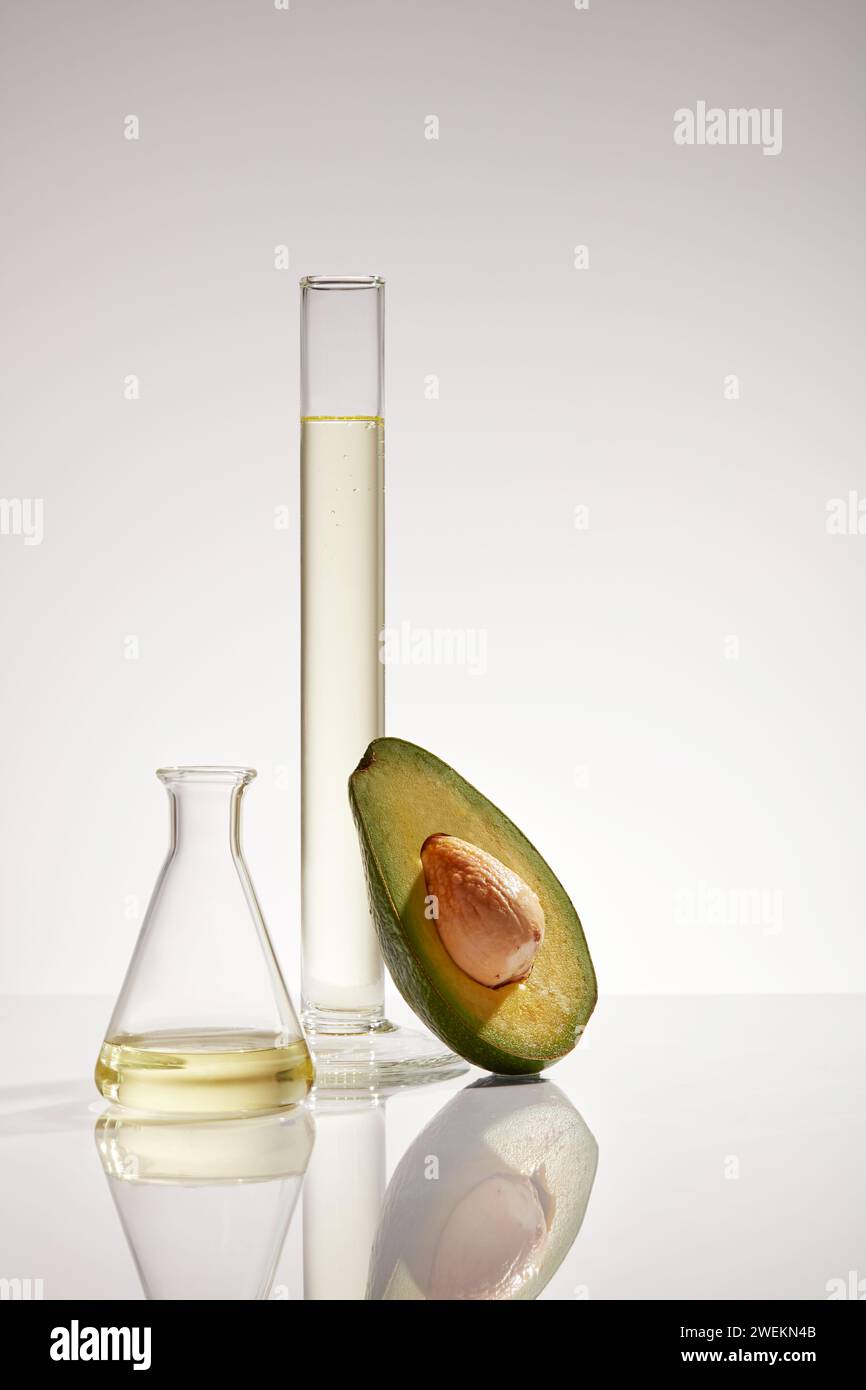 Front view of fresh half an avocado with seeds, test tube and ...