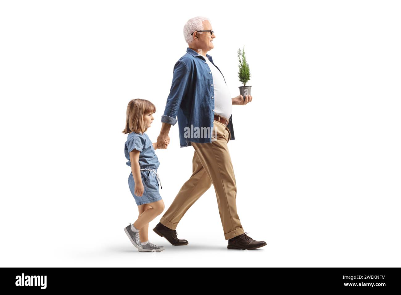 Full length profile shot of a man and a child walking and holding a ...