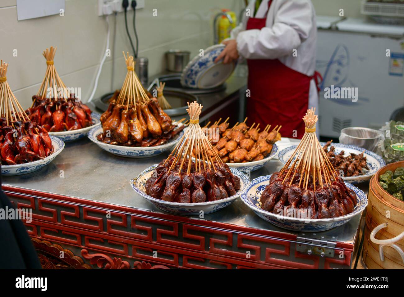 The traditional Chinese food on display with a man cooking in the ...