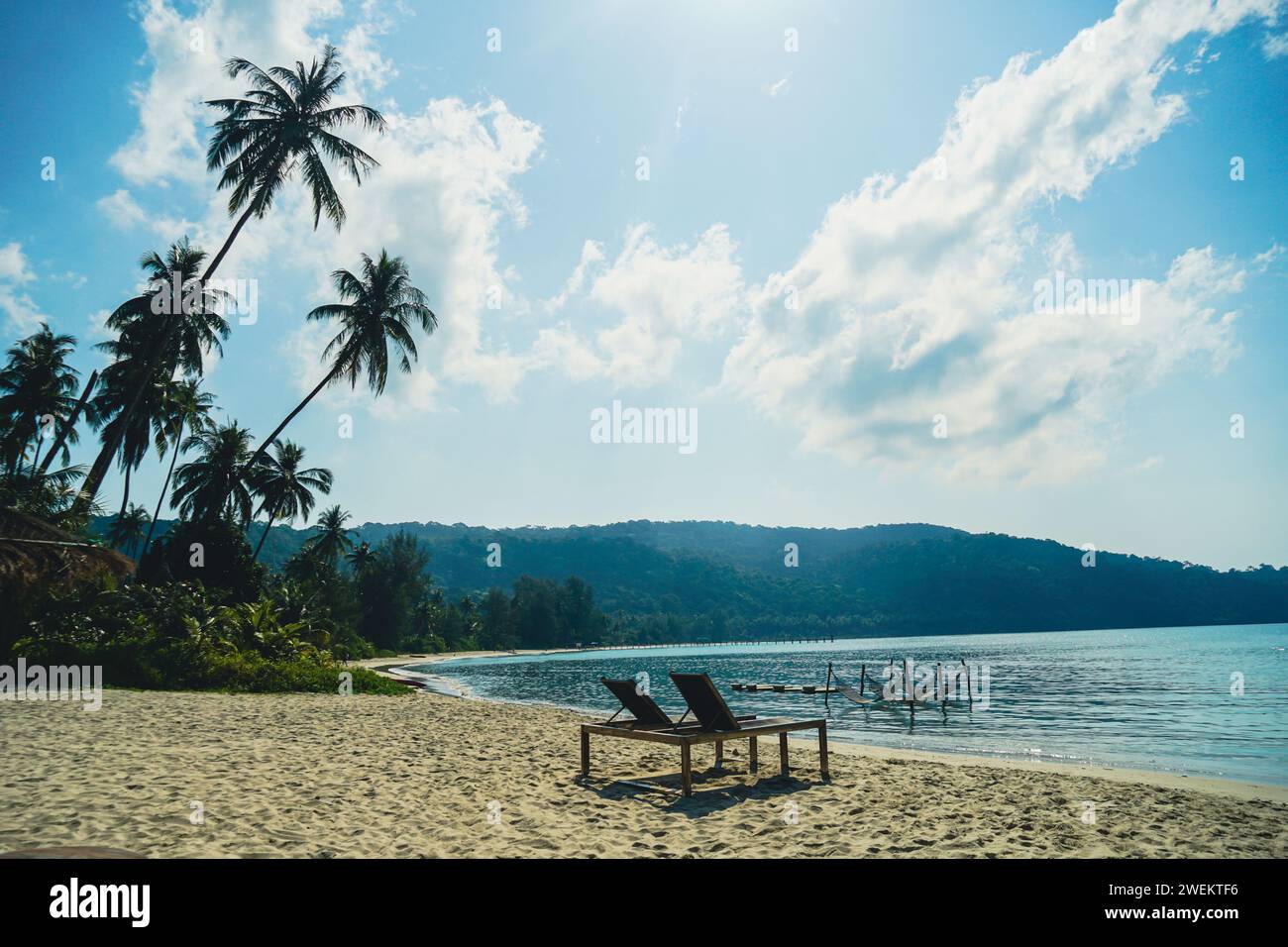 Two beach chairs side by side on sandy ocean front with view over blue ...
