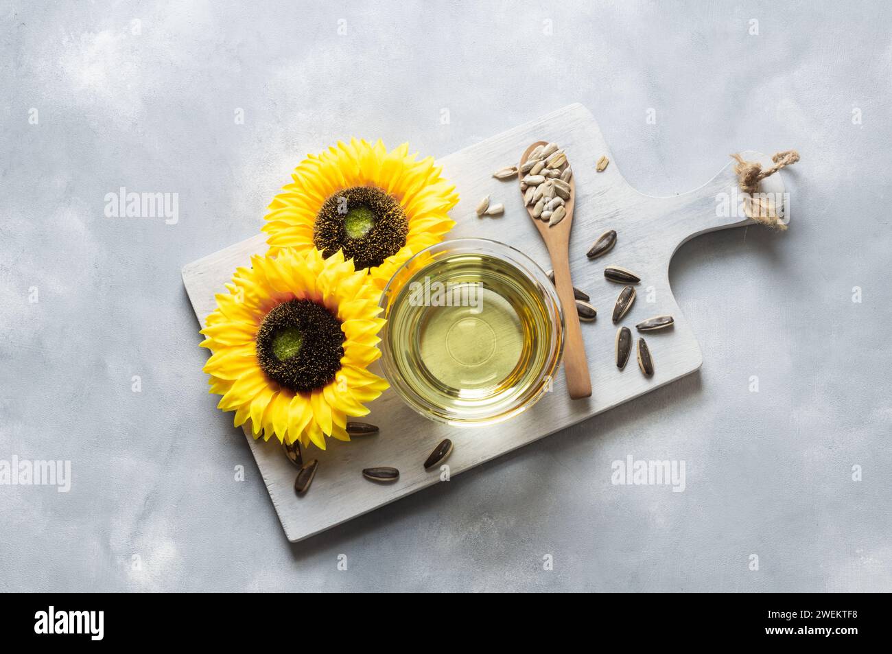 Bottle of sunflower seed oil with flowers on rustic background, cooking ...