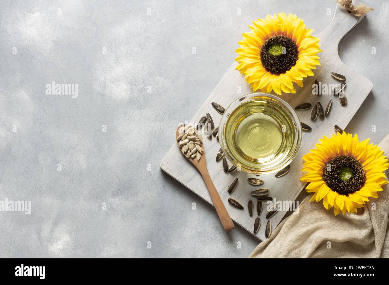 Bottle of sunflower seed oil with flowers on rustic background, cooking ...