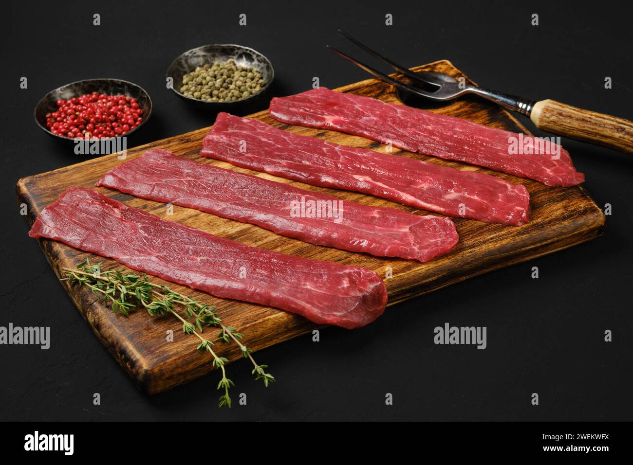 Raw beef strips on black background Stock Photo - Alamy