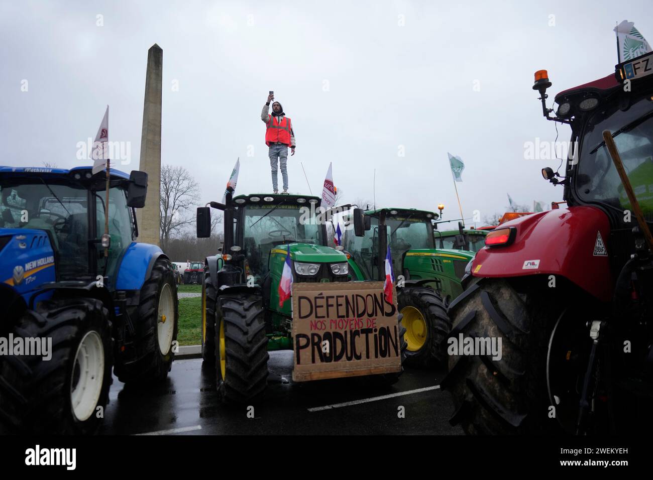A farmer stands atop a tractor as farmers block a roundabout in ...