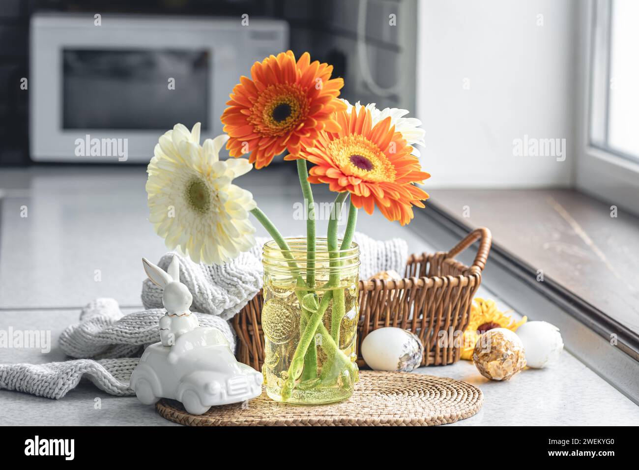 Easter composition with gerbera flowers and eggs in kitchen interior ...
