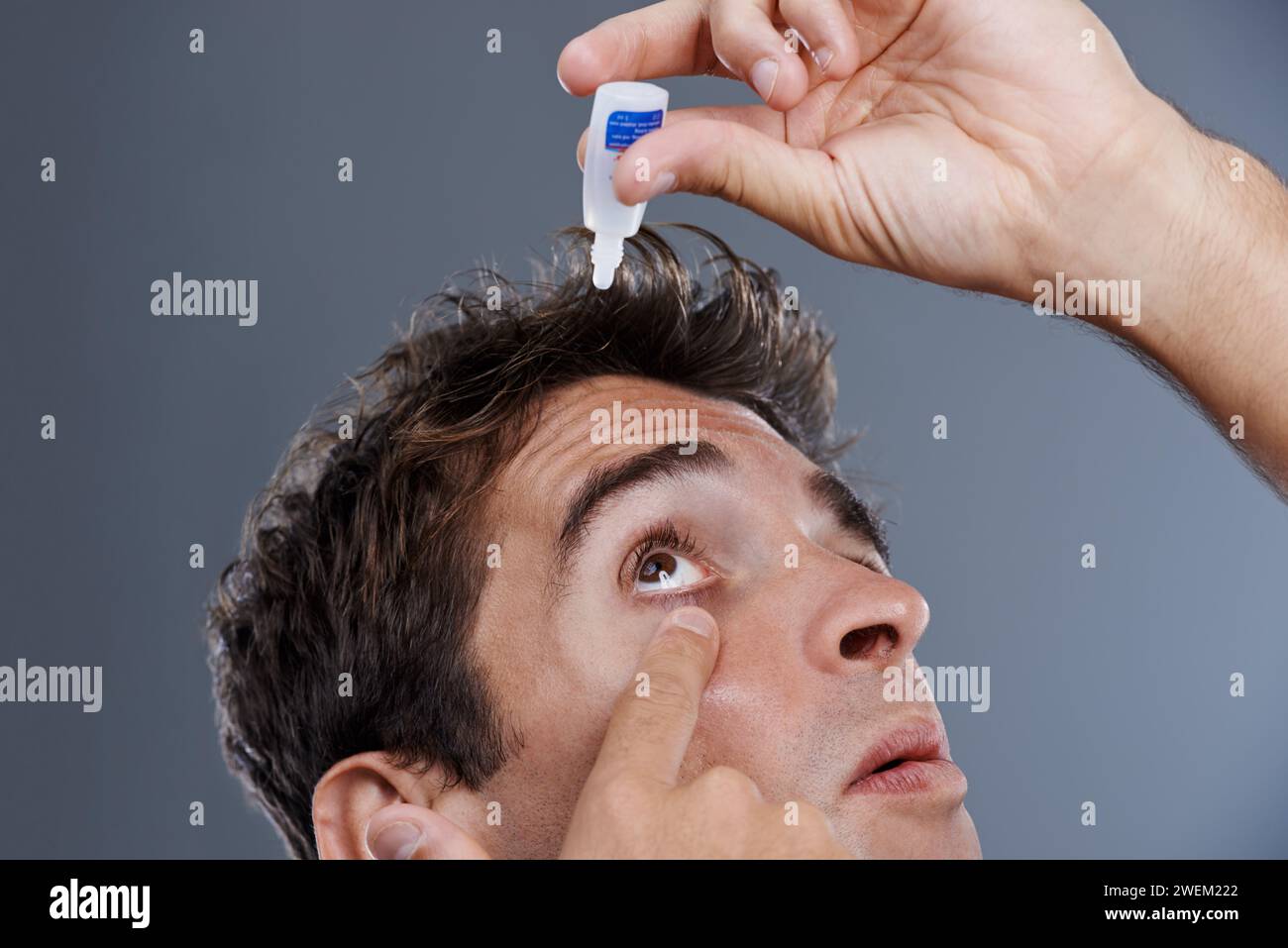 Man, eye drops and vision for allergies or liquid in studio or ...