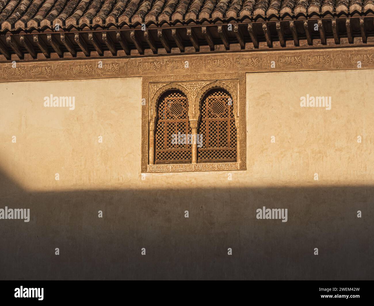 Sunlight on a wall and an engraved window of a famous Arabian palace of ...