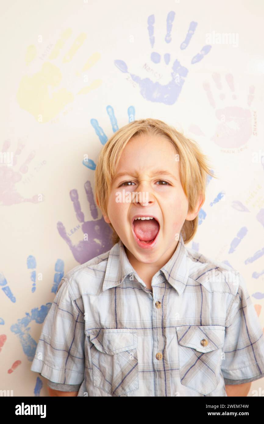Screaming Boy Standing in front of Wall Covered in Handprints Stock ...