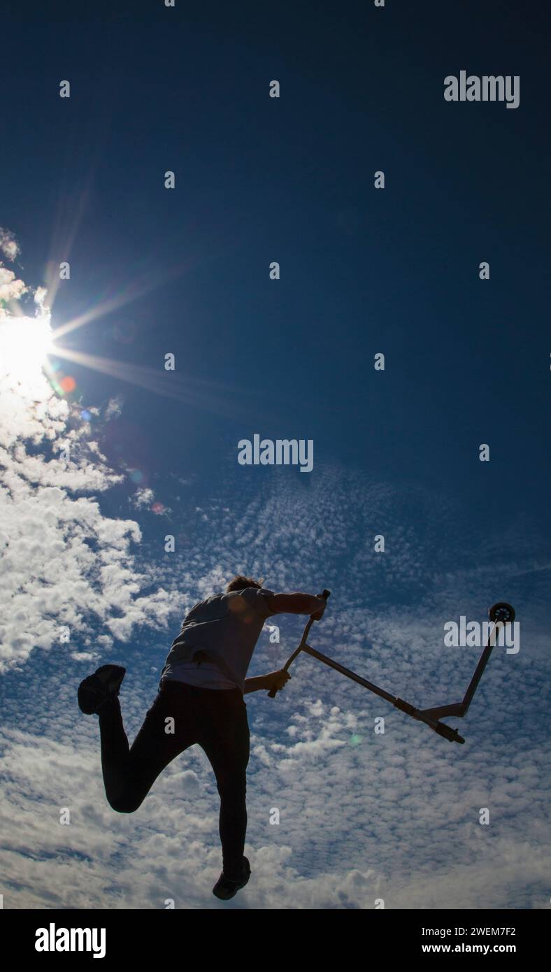 Skateboarder Jumping Mid air against Clouds and Blue Sky Stock Photo ...