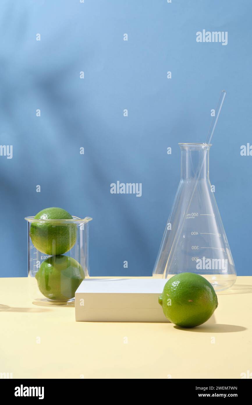 Fresh limes on blue background with lab glassware and white empty ...