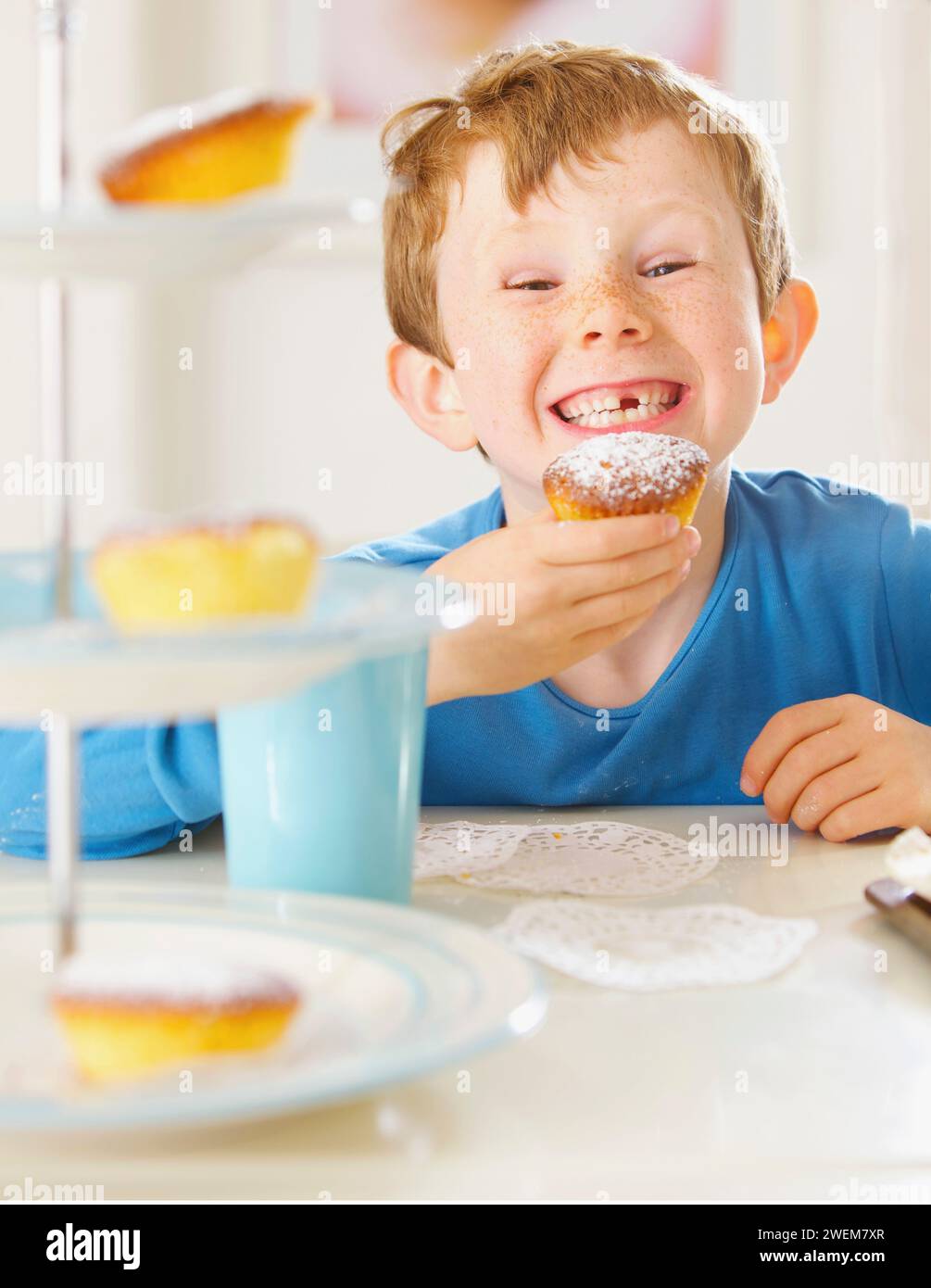 Young boy eating a cupcake Stock Photo - Alamy