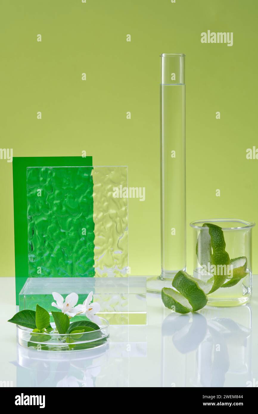 Front view of lab glassware, spiral lime peel and white flower, green ...