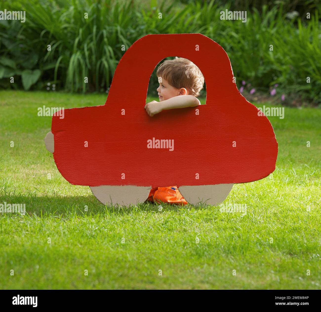 Young Boy Kneeling behind Cardboard Cut Out in Shape of Car Stock Photo ...