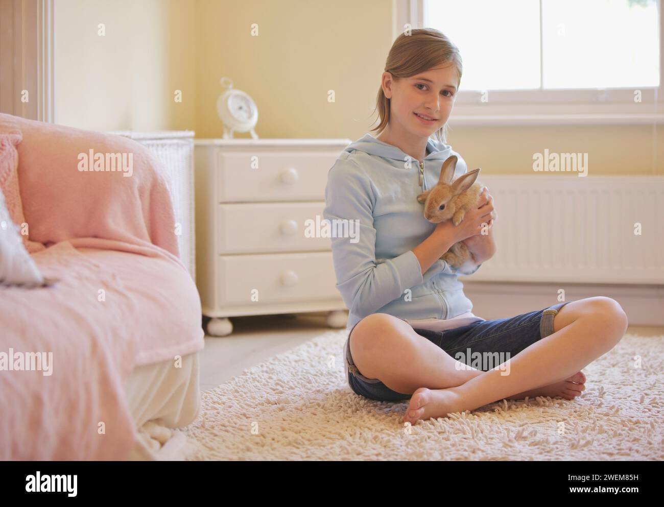 Girl sitting and Holding Rabbit Stock Photo - Alamy