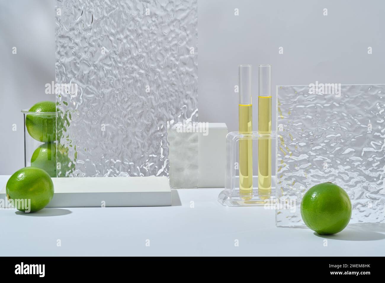 Front view of fresh limes, lab glassware containing yellow liquid ...