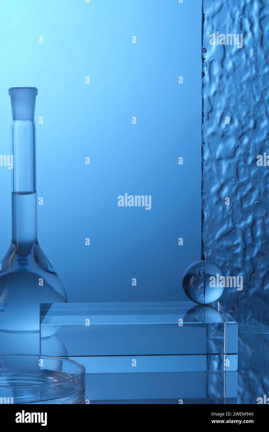 Erlenmeyer flask and petri dish containing transparent liquid, ball and ...