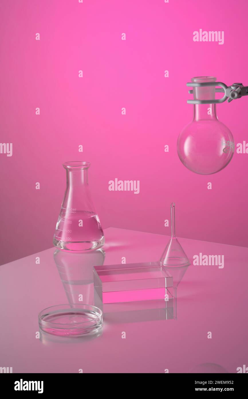 Front view of lab glassware containing transparent liquid on pink ...