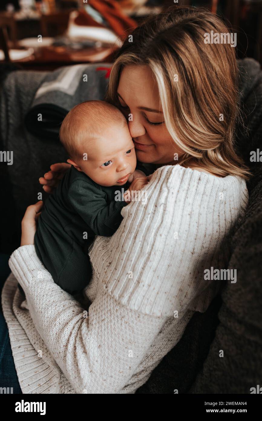 Mom cuddles baby boy face to face on the couch Stock Photo - Alamy