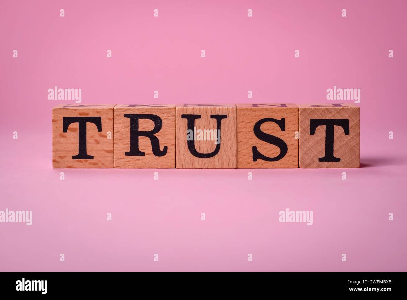 The inscription Trust made of wooden cubes on a plain background. Can ...