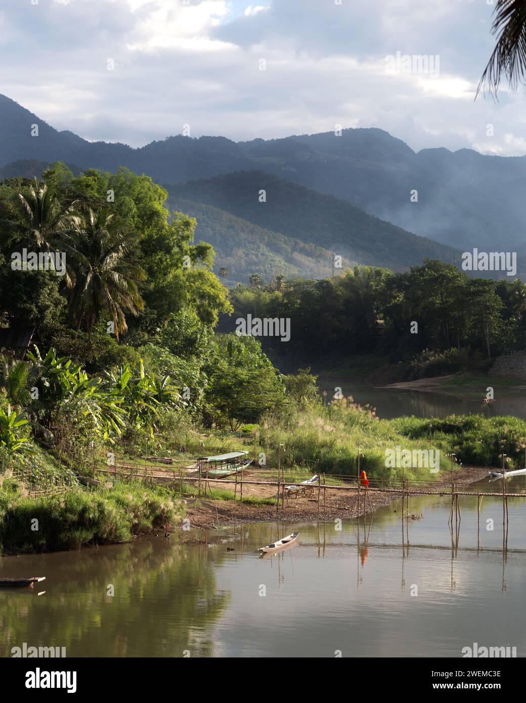 One monk crossing bamboo bridge during sunset in Luang Prabang Stock ...