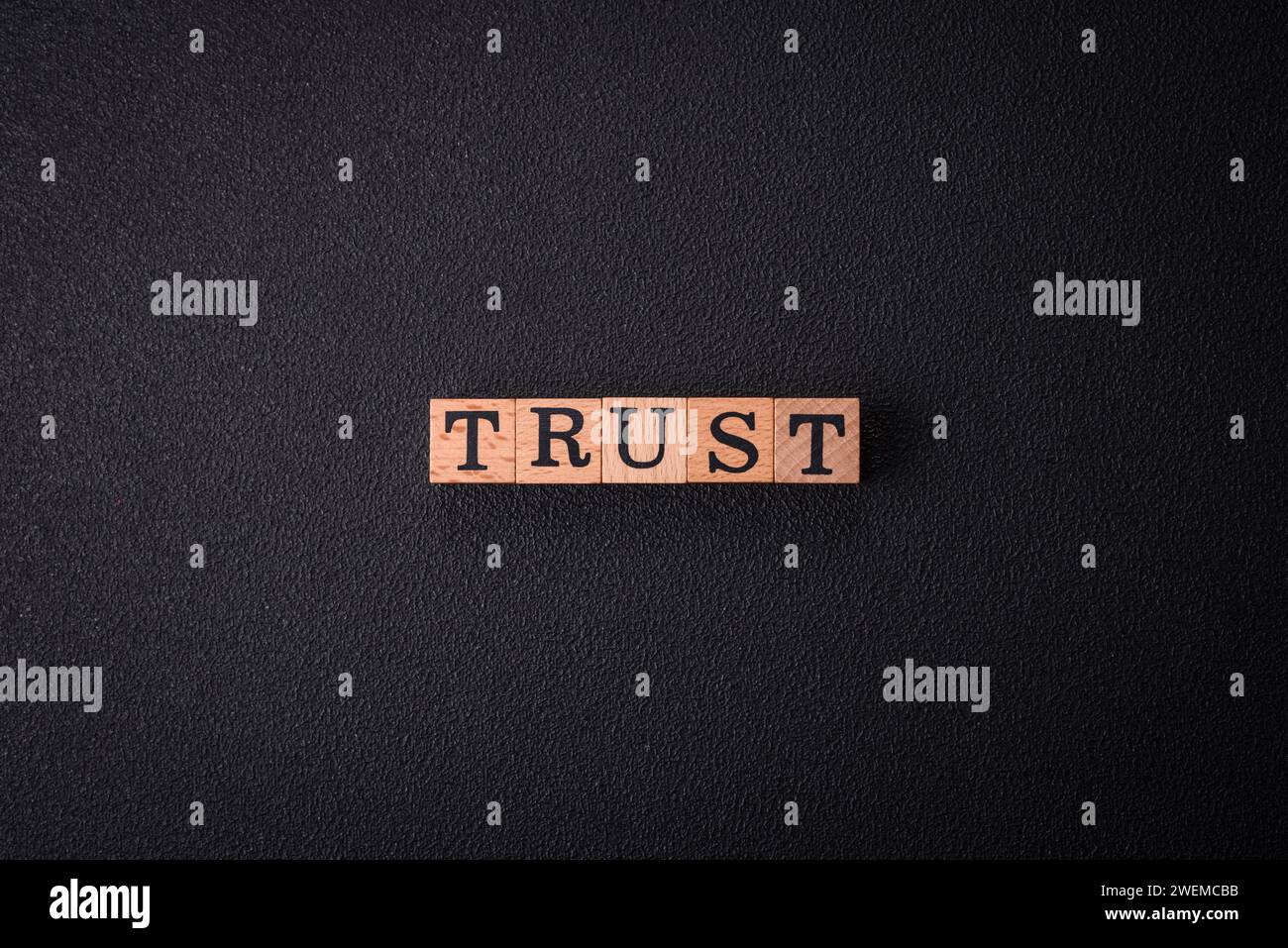 The inscription Trust made of wooden cubes on a plain background. Can ...