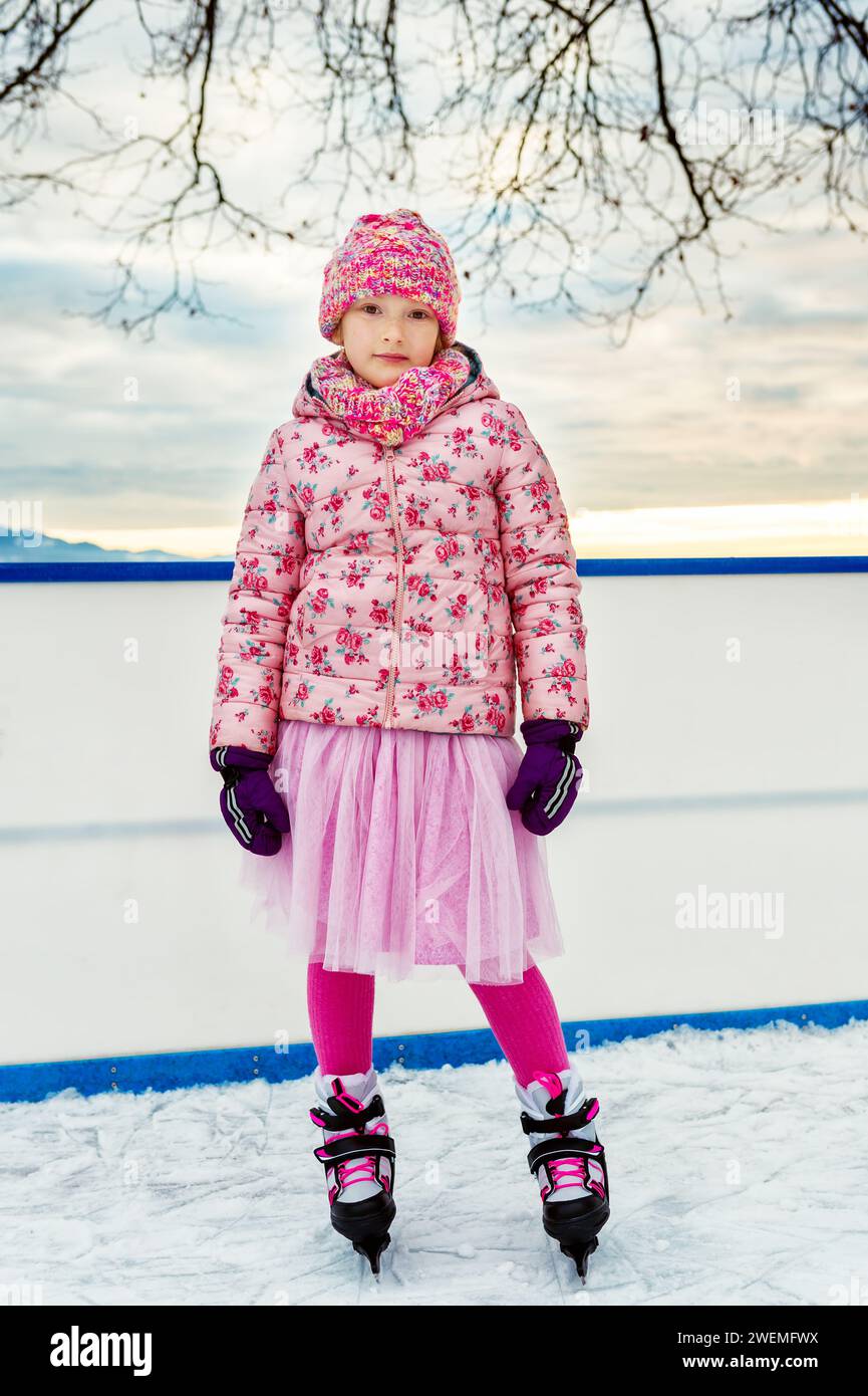 Cute little girl on skating rink wearing pink clothes Stock Photo - Alamy