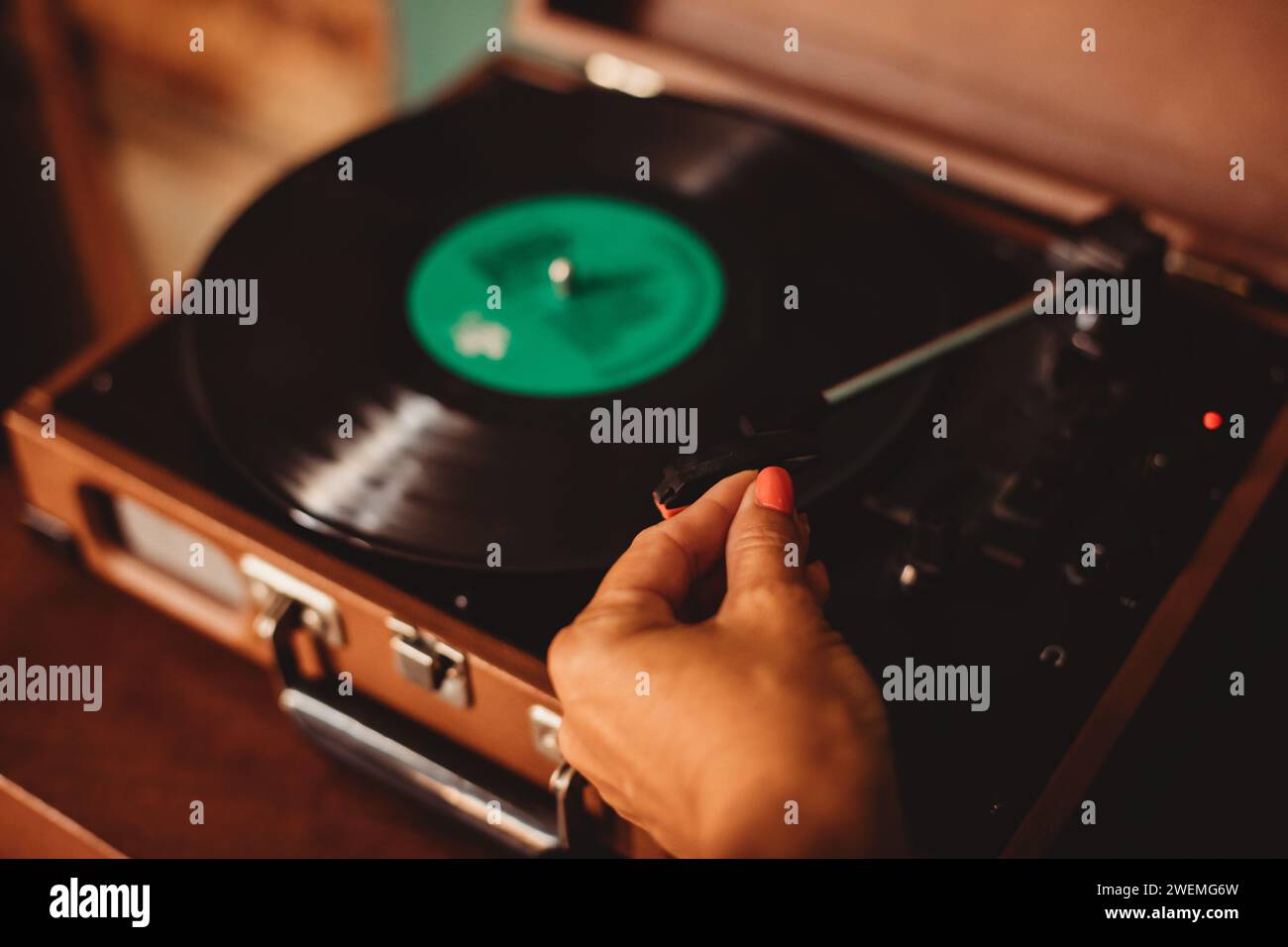 Black woman's hand turning on a vintage record player Stock Photo - Alamy
