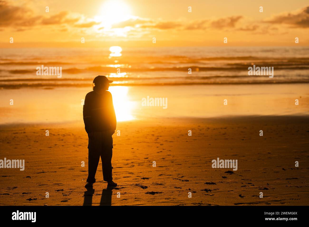 Solitary Figure at Ocean Sunset Stock Photo - Alamy
