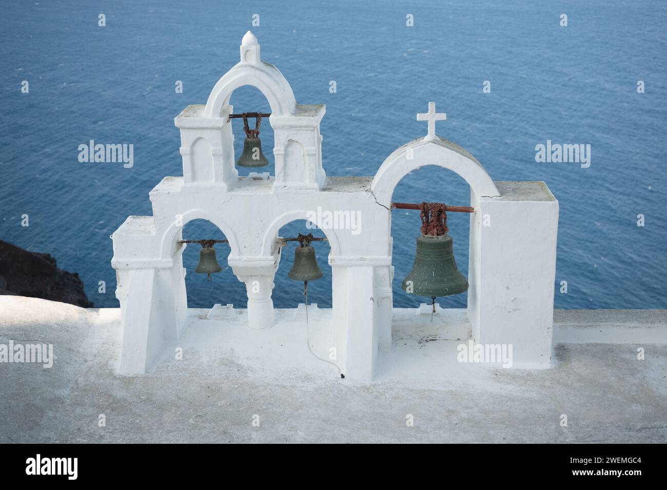 White church bells in Greek architectural style overlooking the sea ...