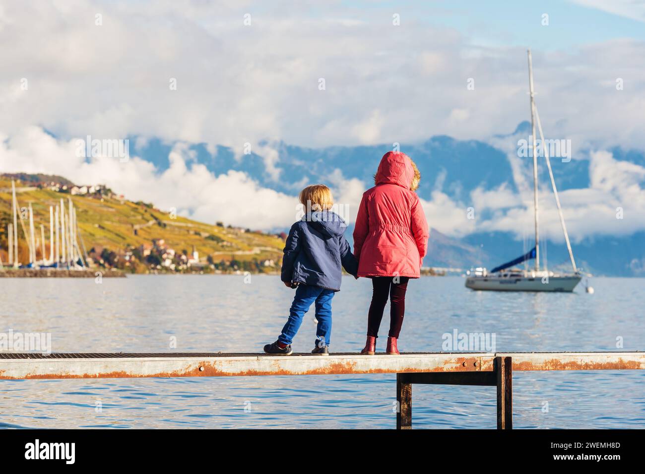 Two kids admiring amazing view of Lake Geneva, Switzerland, back view ...