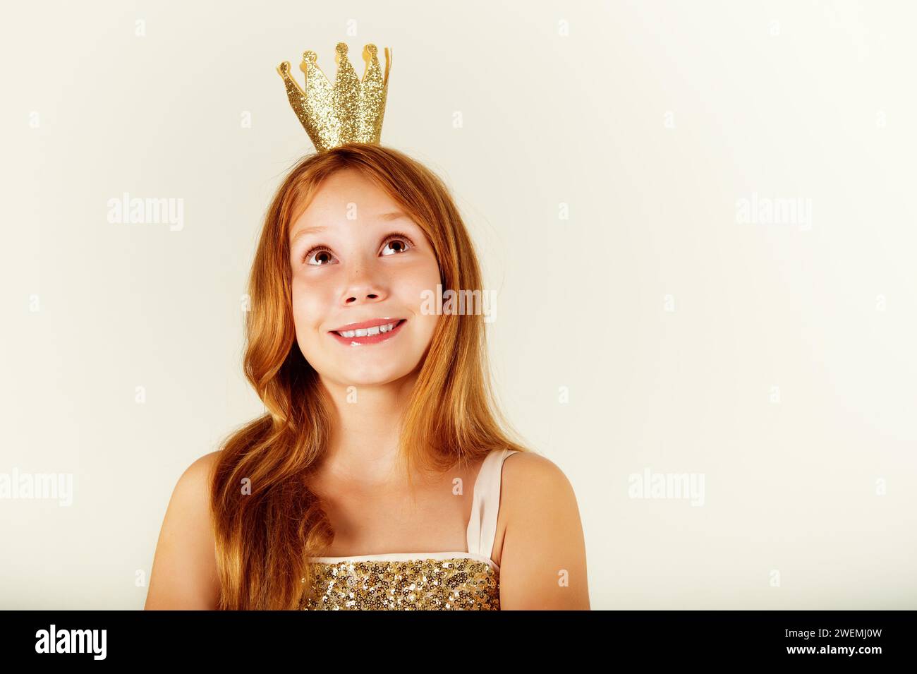 Pretty little girl with beautiful red hair looking up. Little princess ...